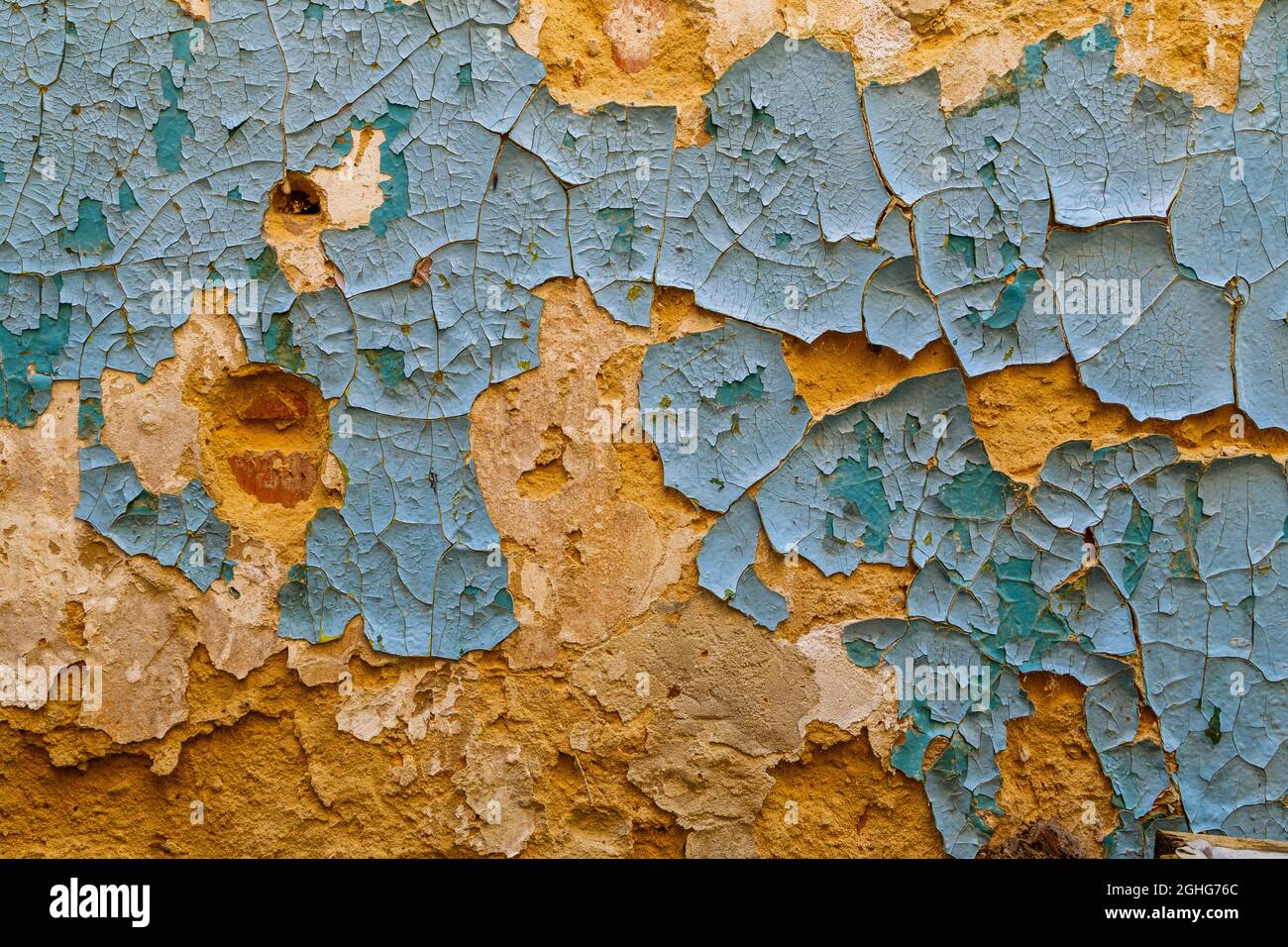 peeling blue paint on yellow sandy plaster wall - close-up full frame ...