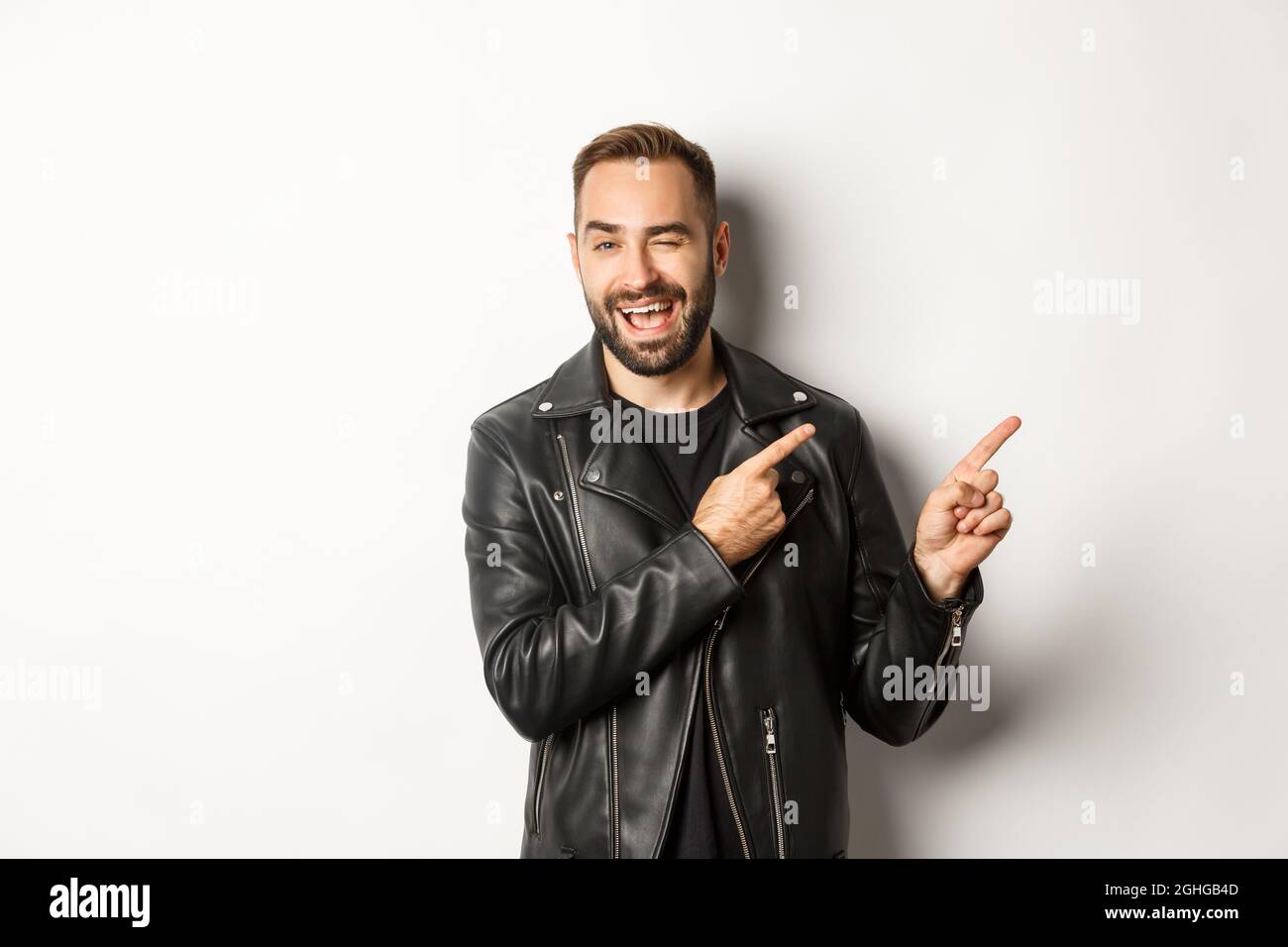 Cheeky guy in leather biker jacket, winking flirty and pointing at ...