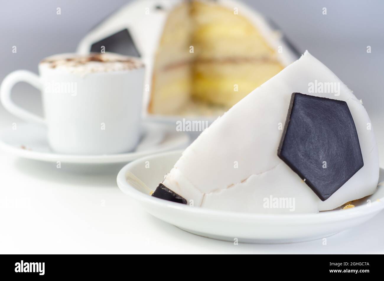 Piece of football cake, sponge filled with frosting and raspberry jam ...