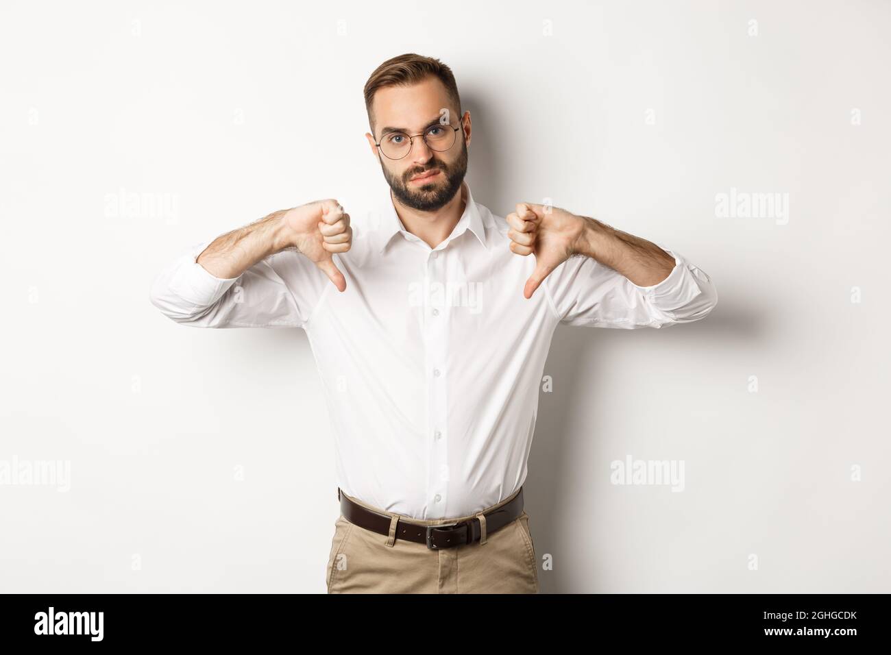 Displeased businessman in glasses showing thumbs down, dislike and ...