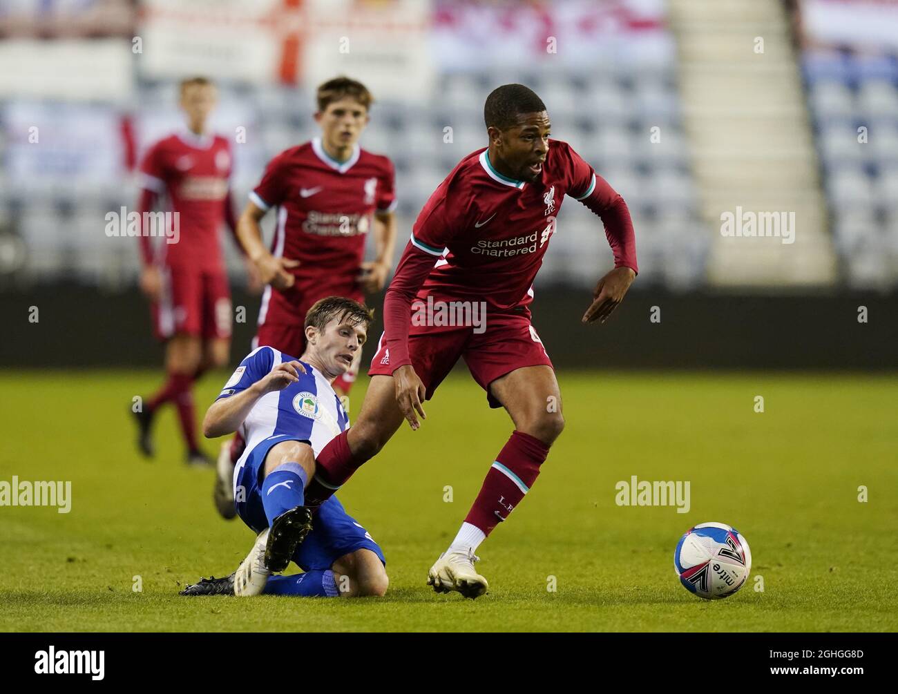 Chris Merrie of Wigan tackles Elijah Dixon-Bonner of Liverpool during ...