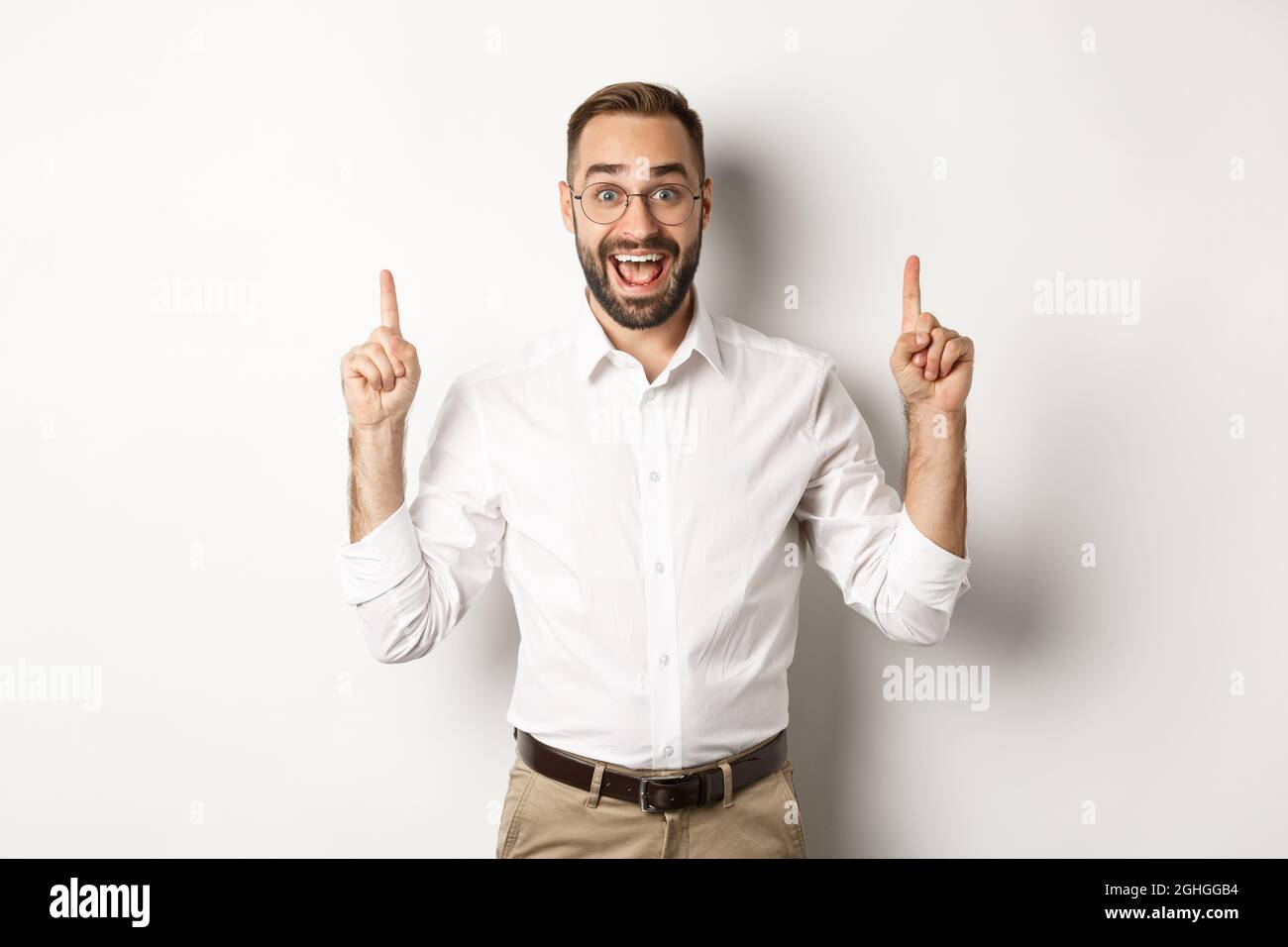 Happy male entrepreneur in business clothes, pointing fingers up and ...