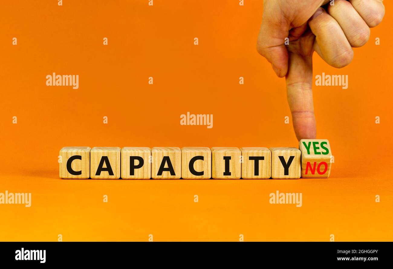 Capacity symbol. Businessman turns a wooden cube and change words ...