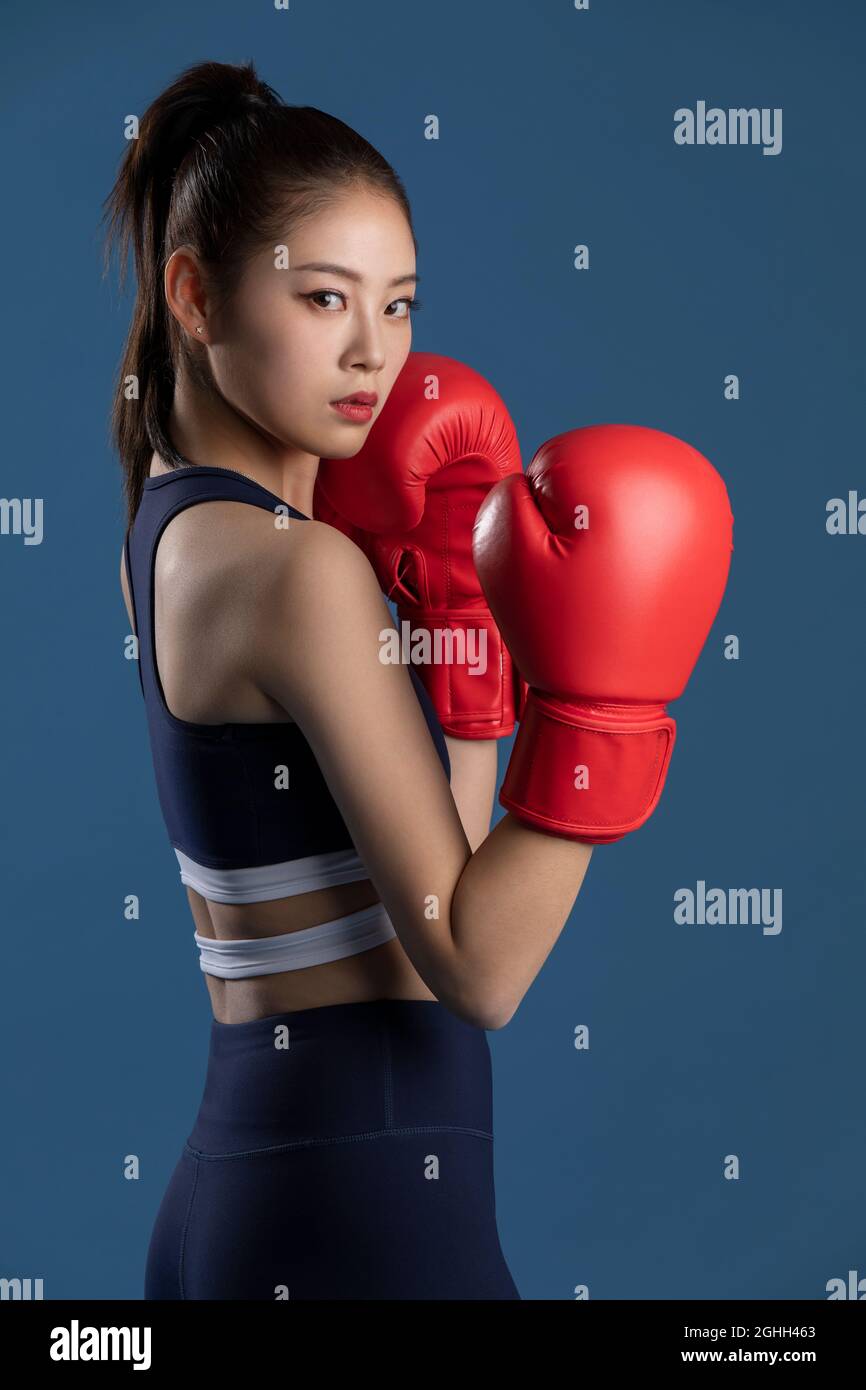 Confident young woman in boxing gloves Stock Photo - Alamy