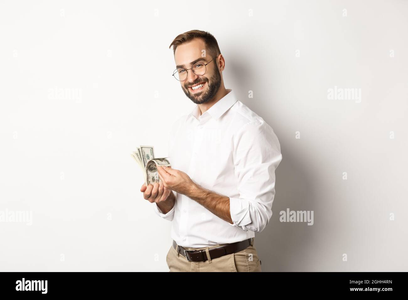 Successful business man counting money and smiling, standing against ...