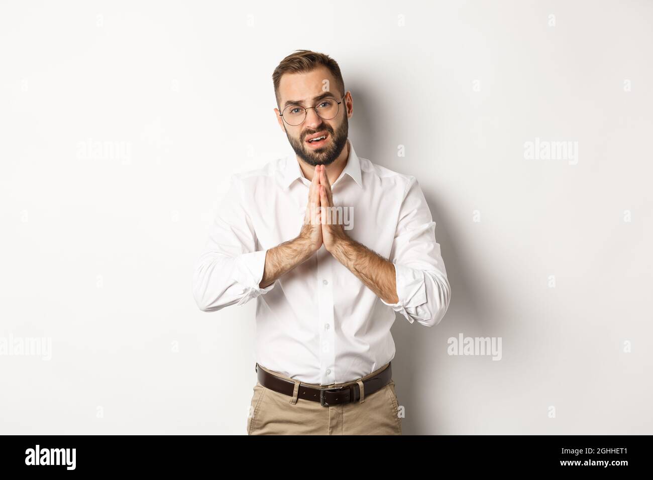 Worried man asking for help, begging for favour, standing over white ...