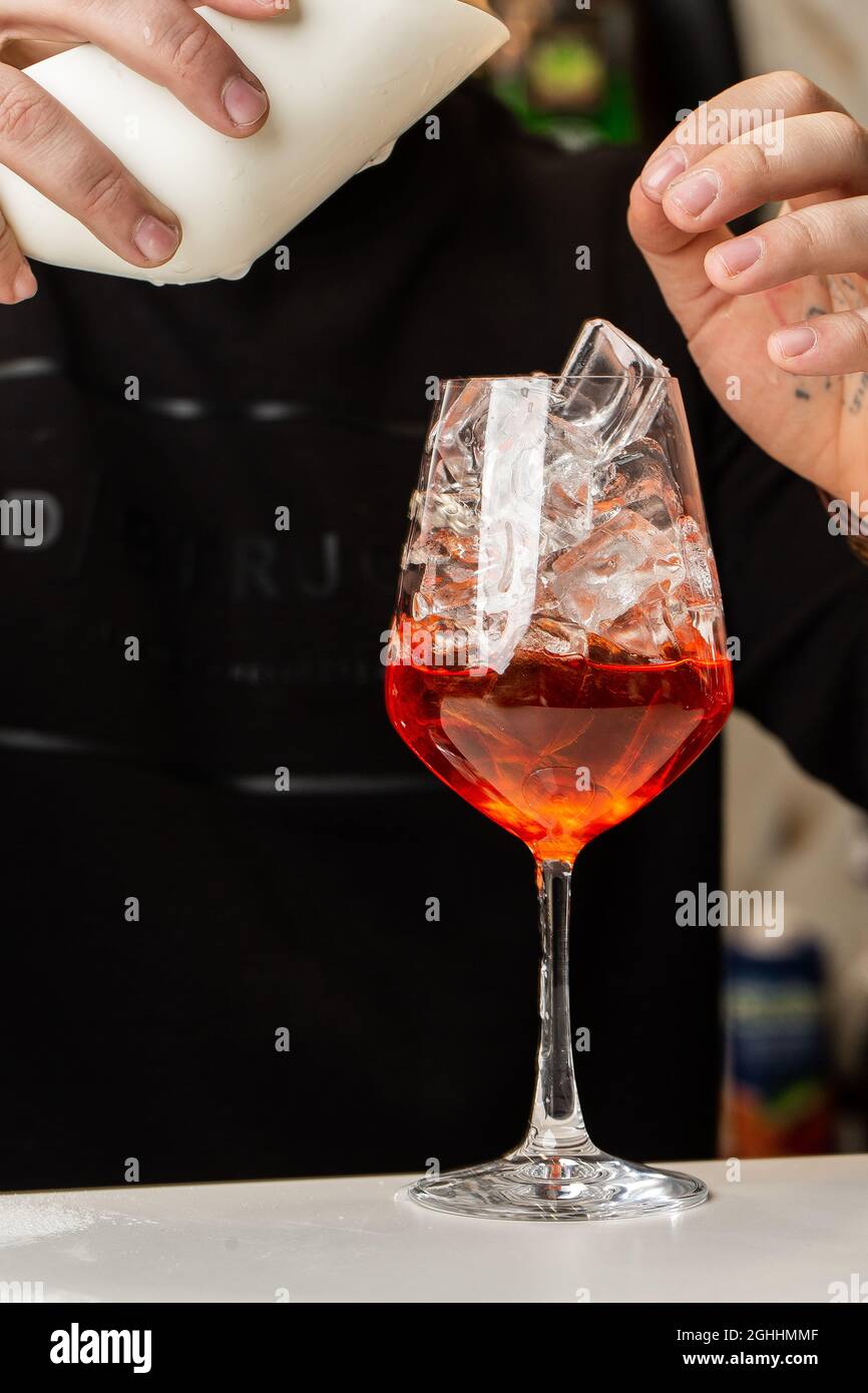 Bartender preparing on the counter Aperol Spritz, a classic refreshing ...