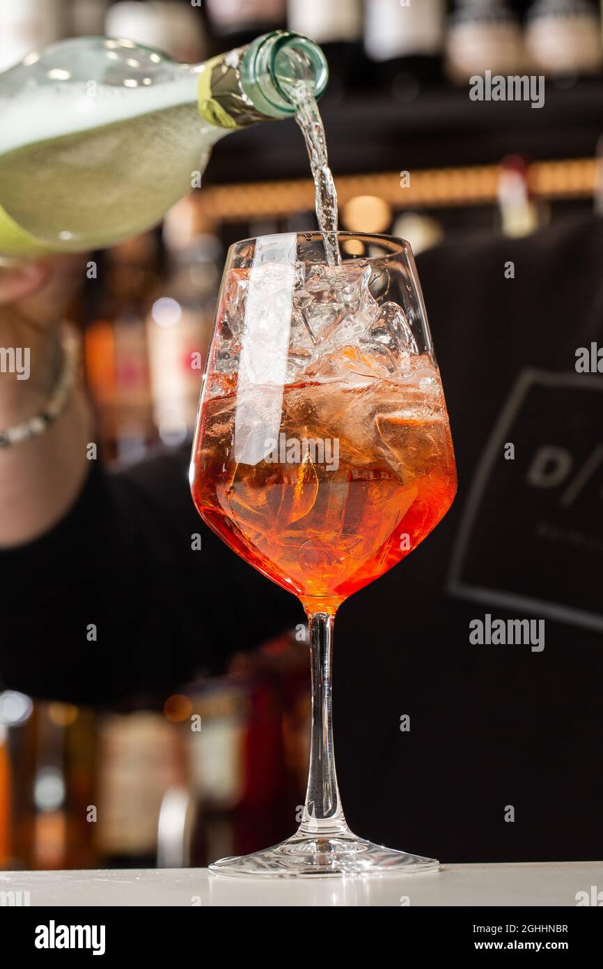 Bartender preparing on the counter Aperol Spritz, a classic refreshing ...