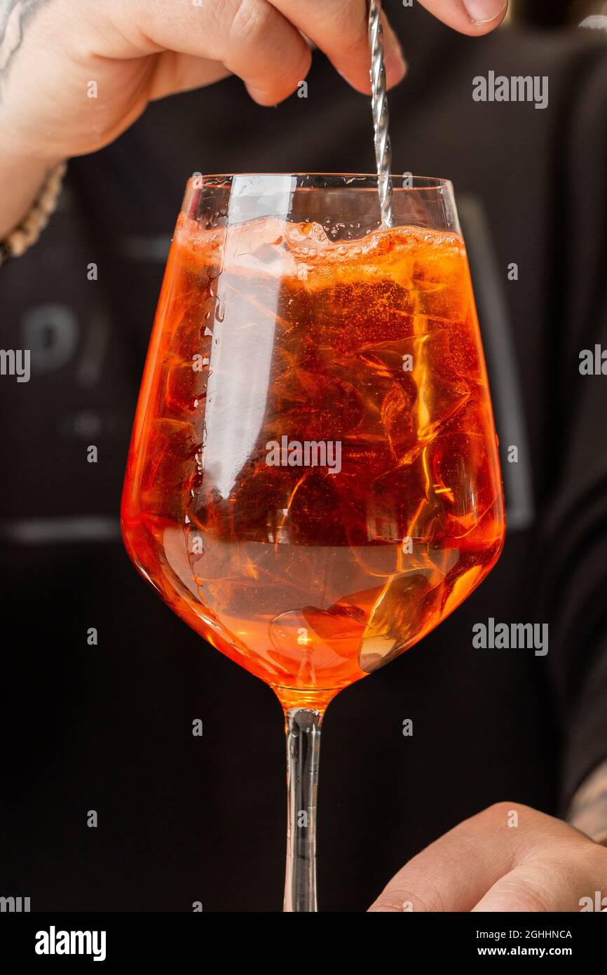 Bartender preparing on the counter Aperol Spritz, a classic refreshing ...