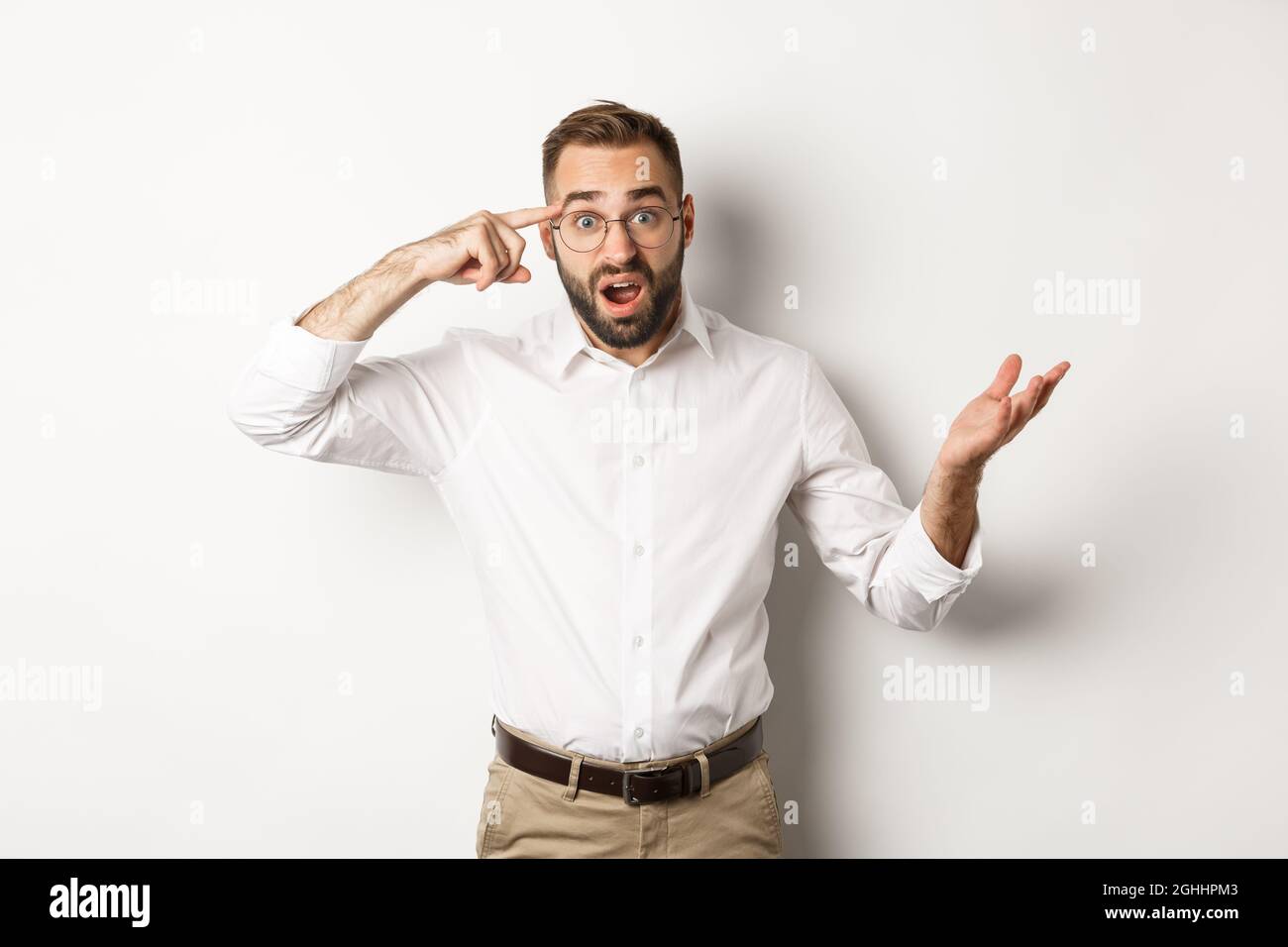 Confused and shocked man pointing at head, scolding employee for acting ...