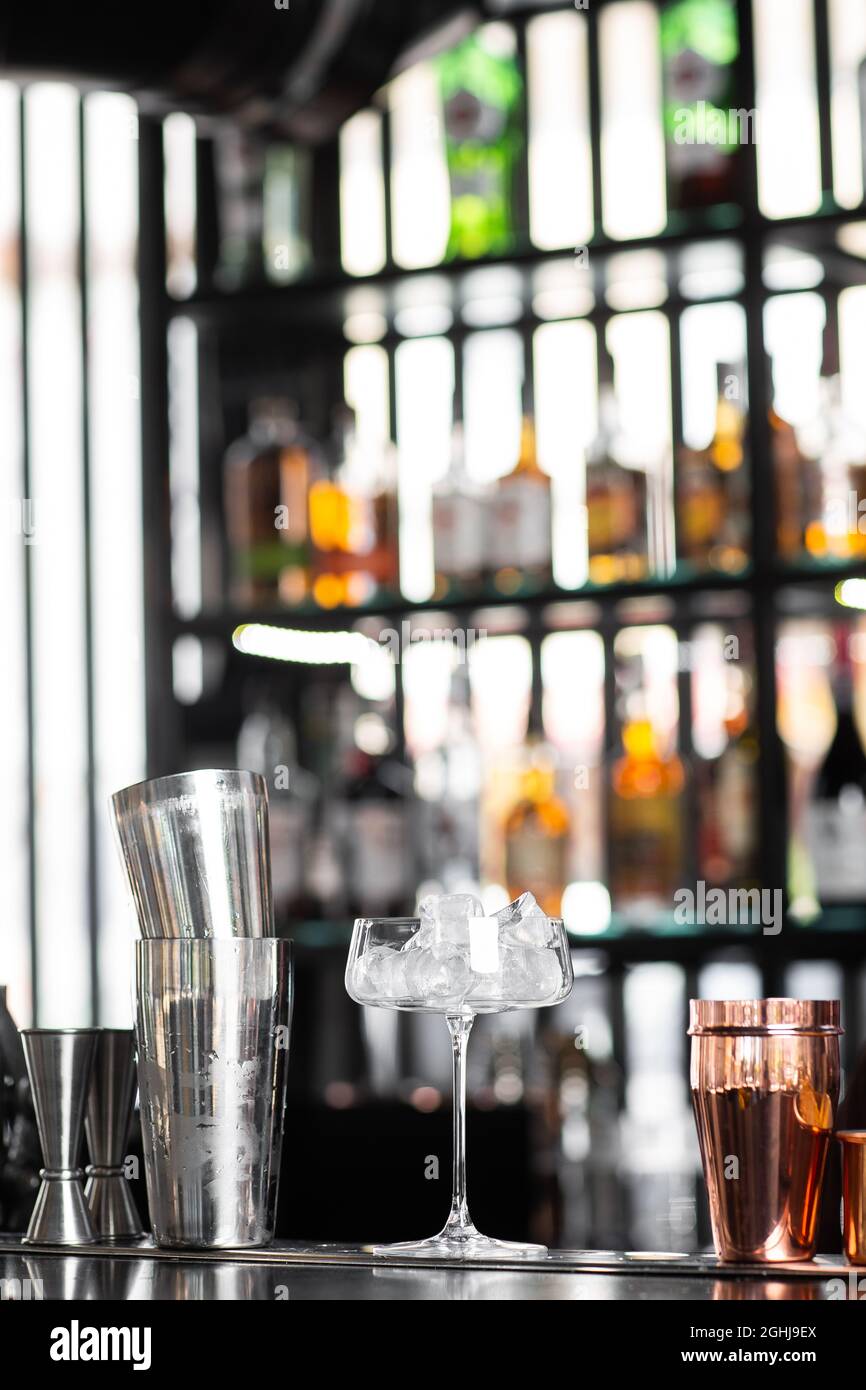 beautiful transparent glass with ice and steel cup stand on the bar ...