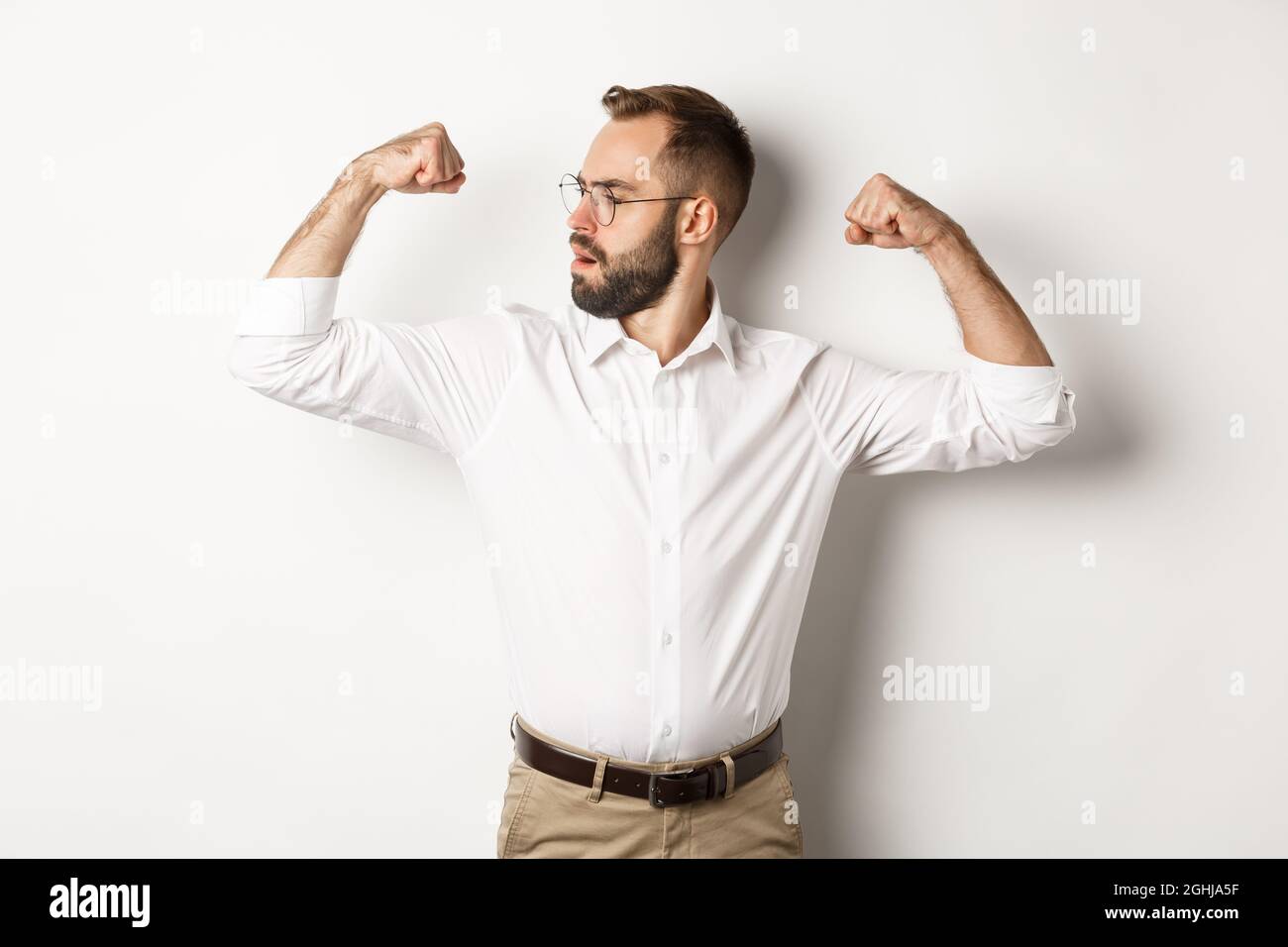 Successful businessman flex biceps, showing muscles and looking ...