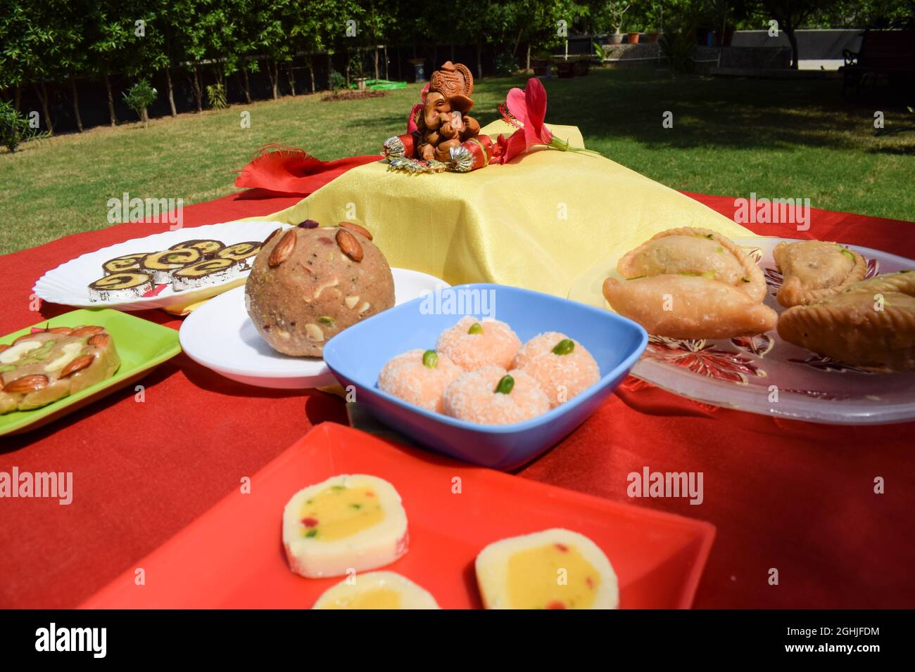 Selective focus of Lord Ganesha with Variety of assorted Indian sweets ...