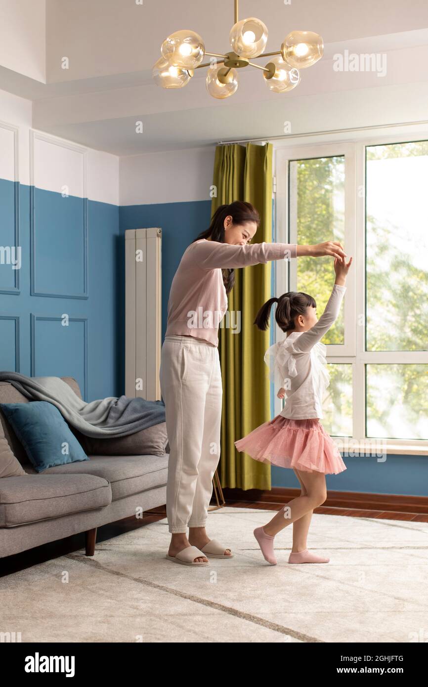 Young mother and daughter dancing at home Stock Photo - Alamy