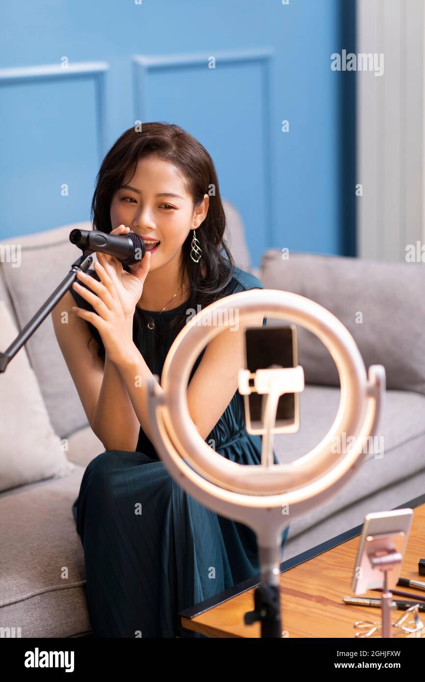 Young woman doing live webcast at home Stock Photo - Alamy