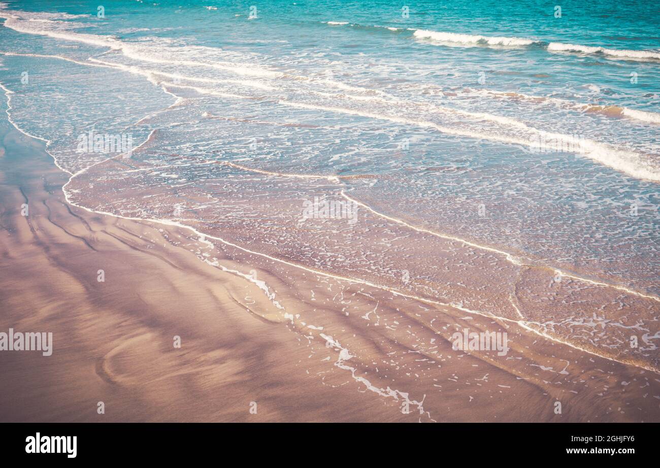 waves washing ashore on the washed-out sand seen from above in Brittany ...