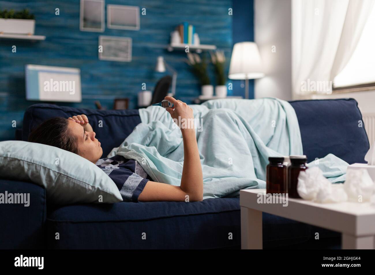 Caucasian woman feeling sick measuring temperature with digital ...