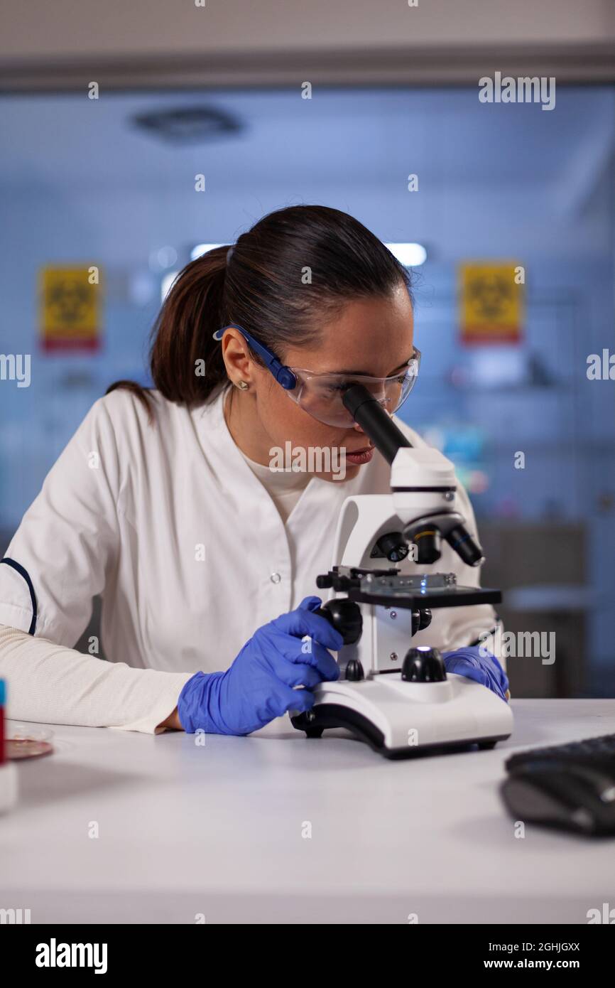 Medicine researcher woman working with microscope in chemical ...