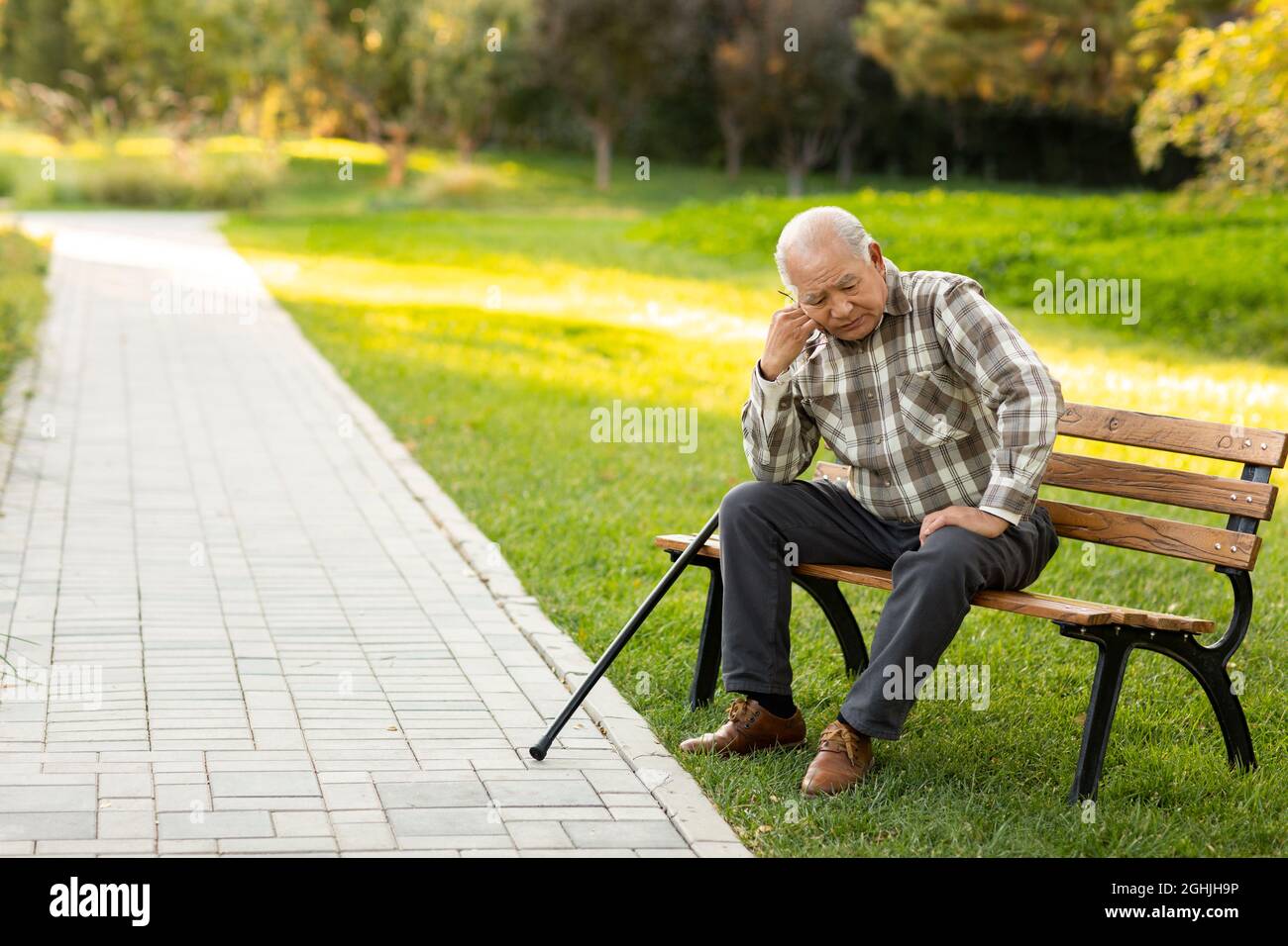 Lonely senior man sitting on park bench Stock Photo - Alamy
