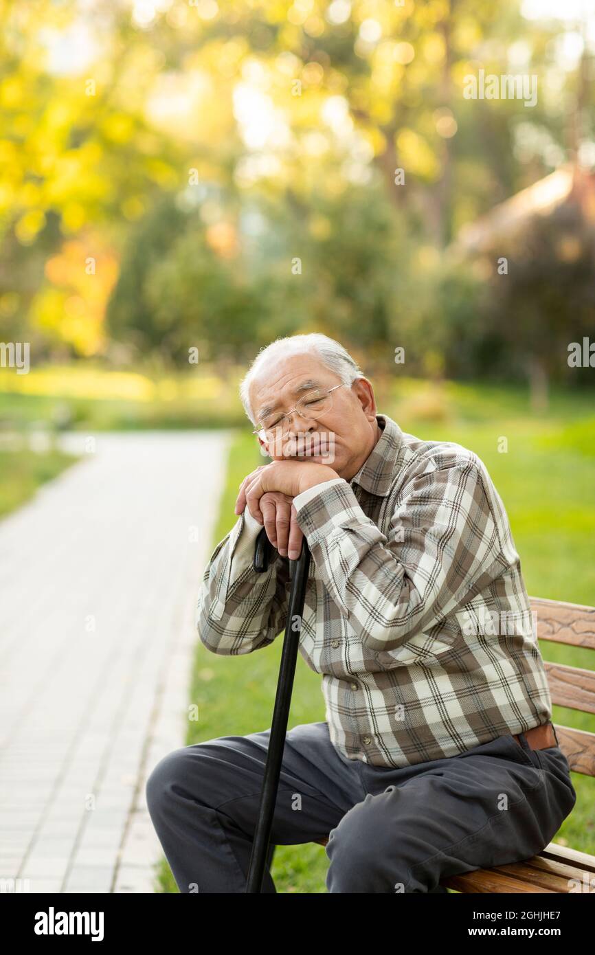 Lonely senior man sitting on park bench Stock Photo - Alamy