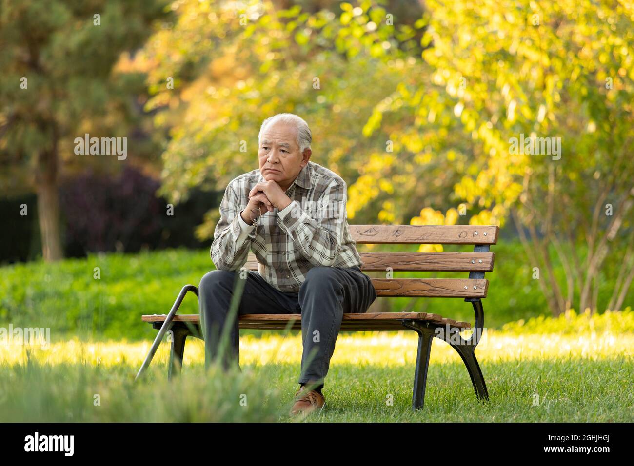 Lonely senior man sitting on park bench Stock Photo - Alamy