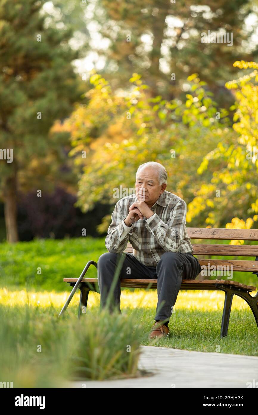 Lonely senior man sitting on park bench Stock Photo - Alamy