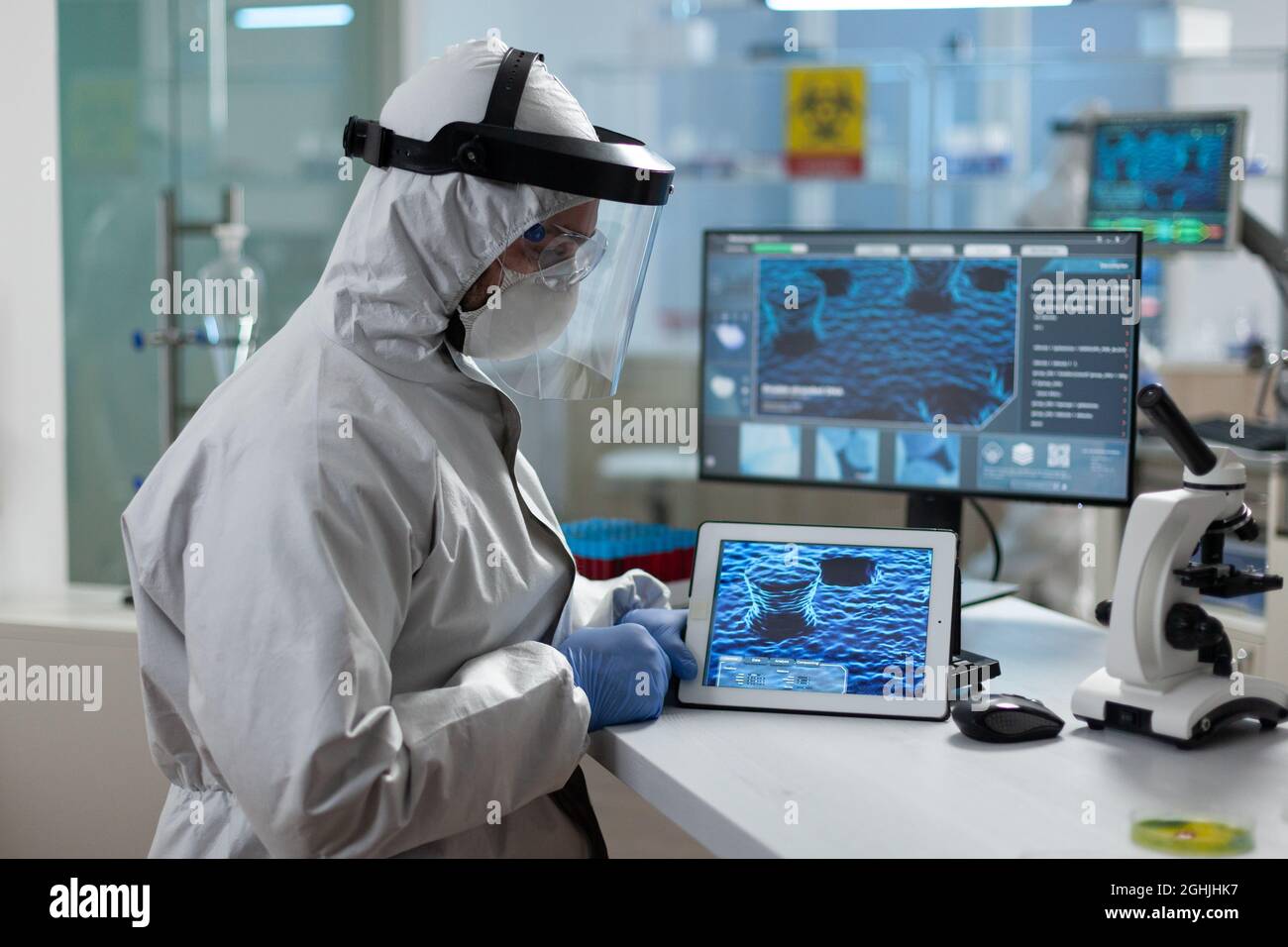 Chemist researcher wearing covid19 protective equipment looking at ...