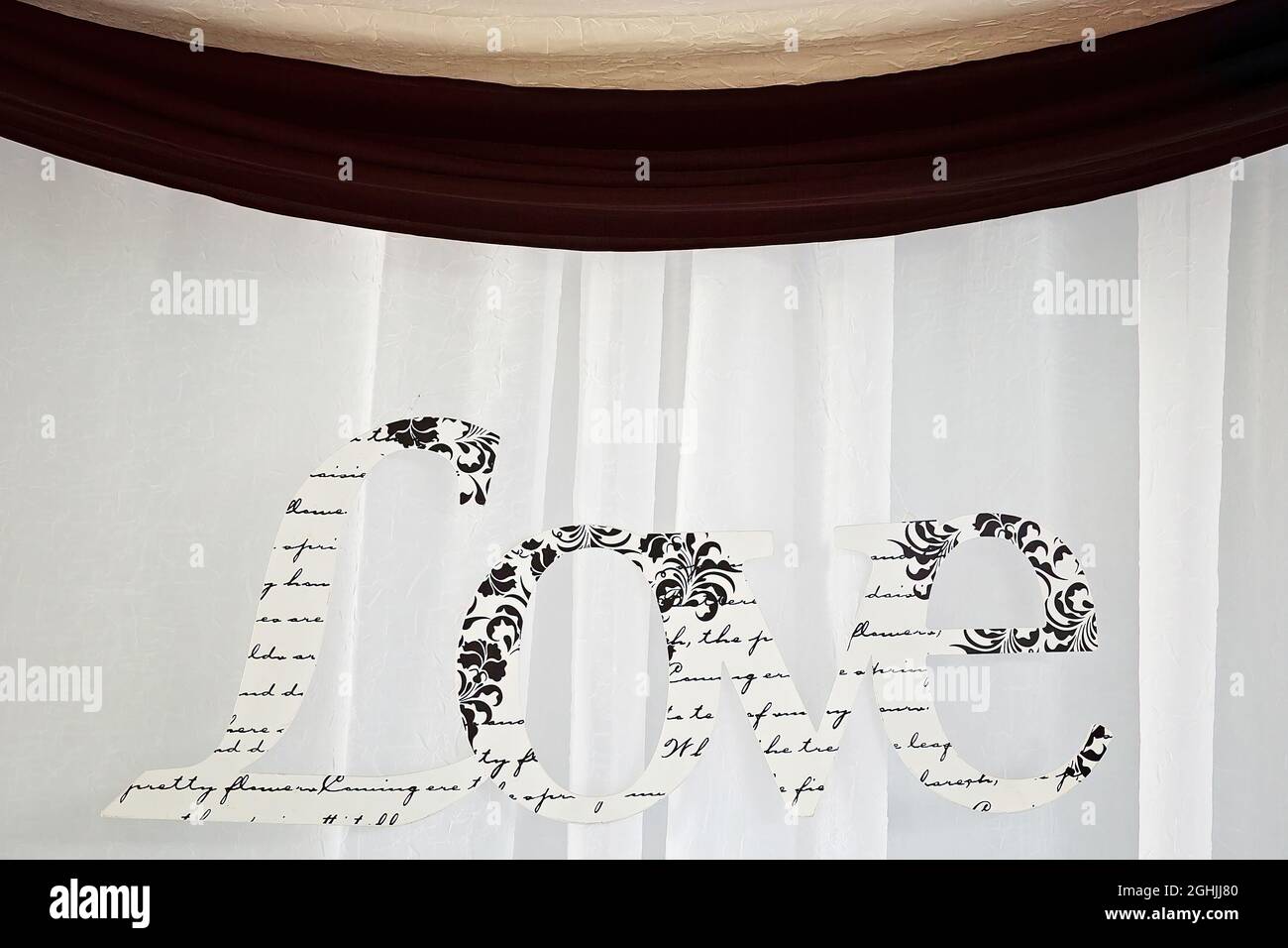 The word Love hanging from curtain drapes as a background for a wedding ...