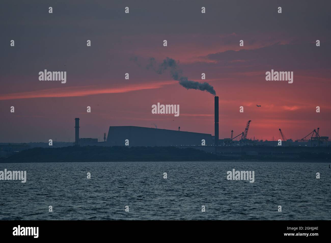 Telephoto view of epic red sunset over Dublin port and Covanta Plant ...
