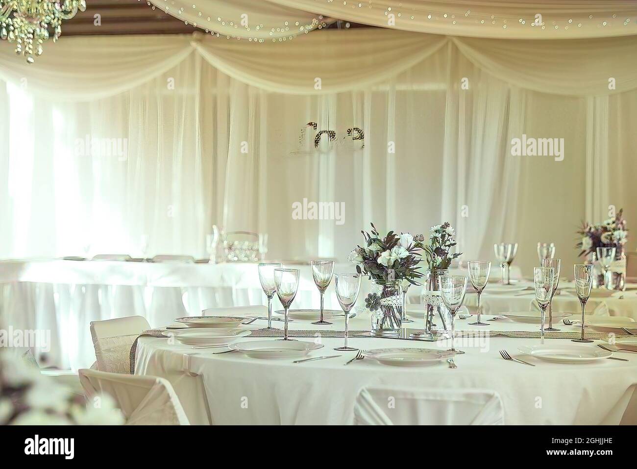 Wedding reception set up with elegant tables prepared with crockery ...