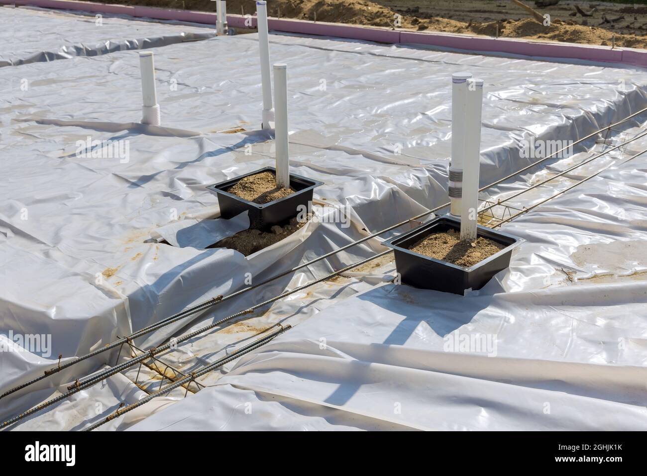 Plastic vapor barrier on slab with plumbing pvc pipes of foundation ...