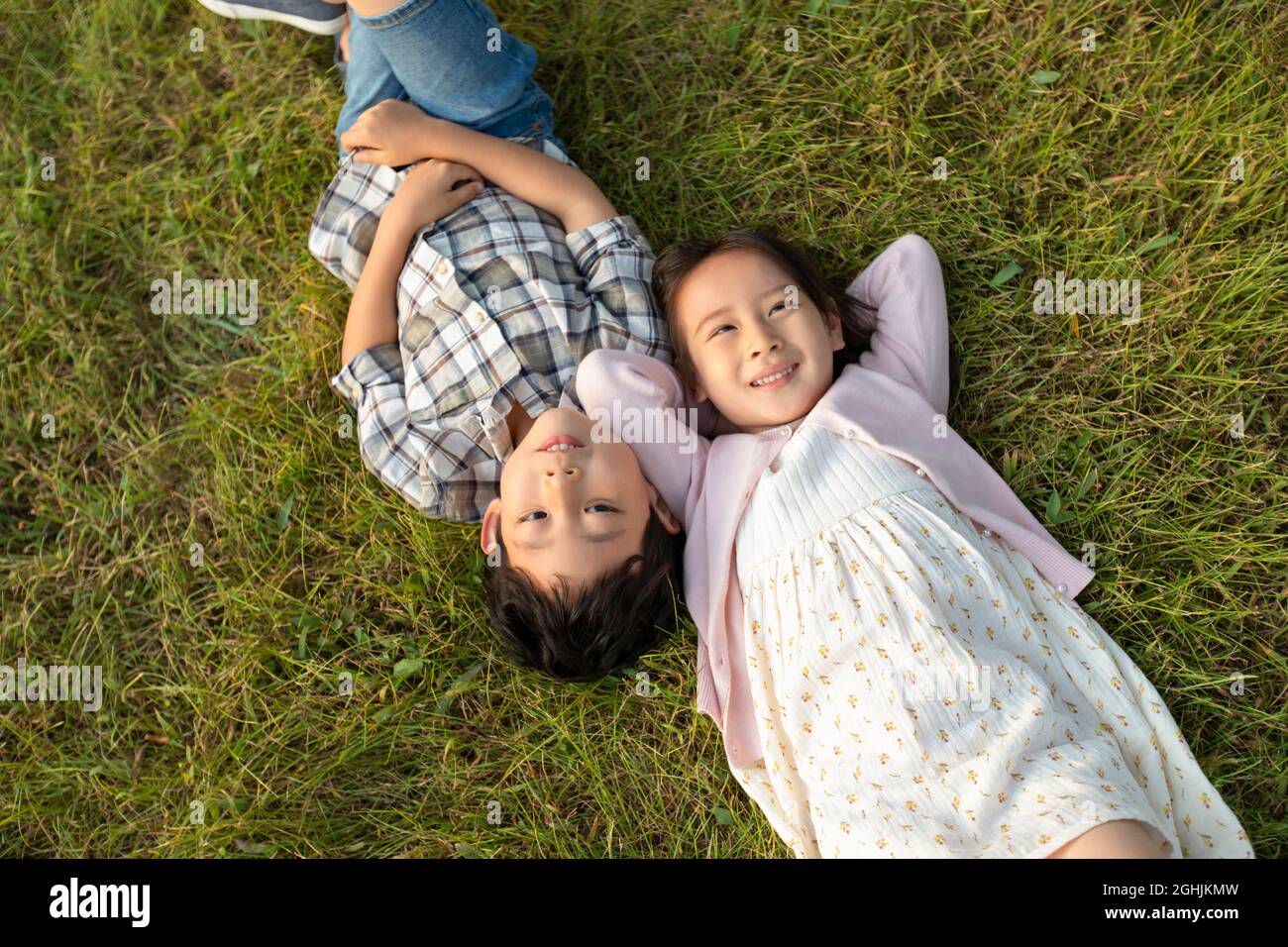 Happy children lying on the grass Stock Photo - Alamy