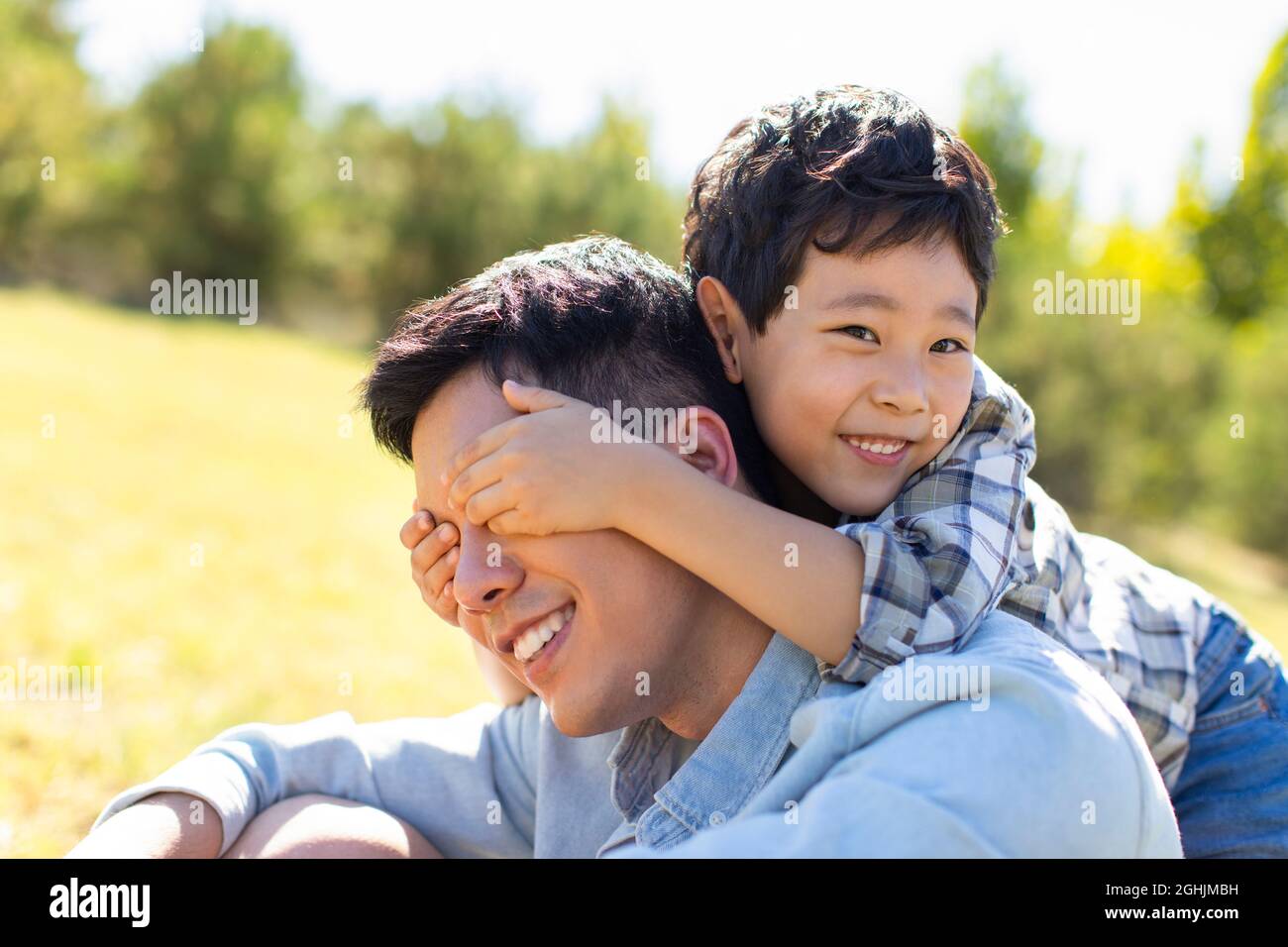 Happy father and son relaxing on meadow Stock Photo - Alamy
