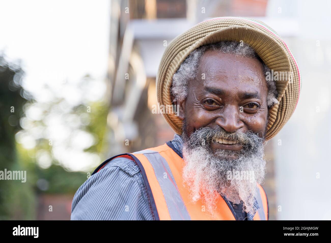 black postman wearing knitted hat on a sunny hot day London Greenwich ...