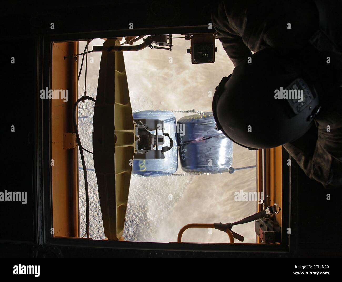 A CH-47 Chinook crew chief observes a slingload of fuel from the load ...