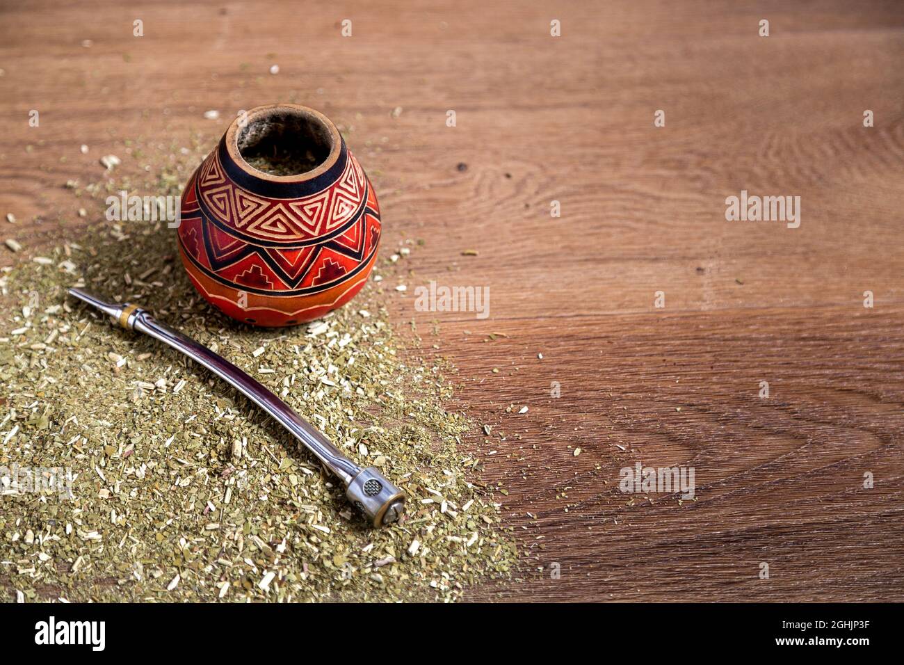 Traditional mate made of calabash over a wooden table with yerba mate ...