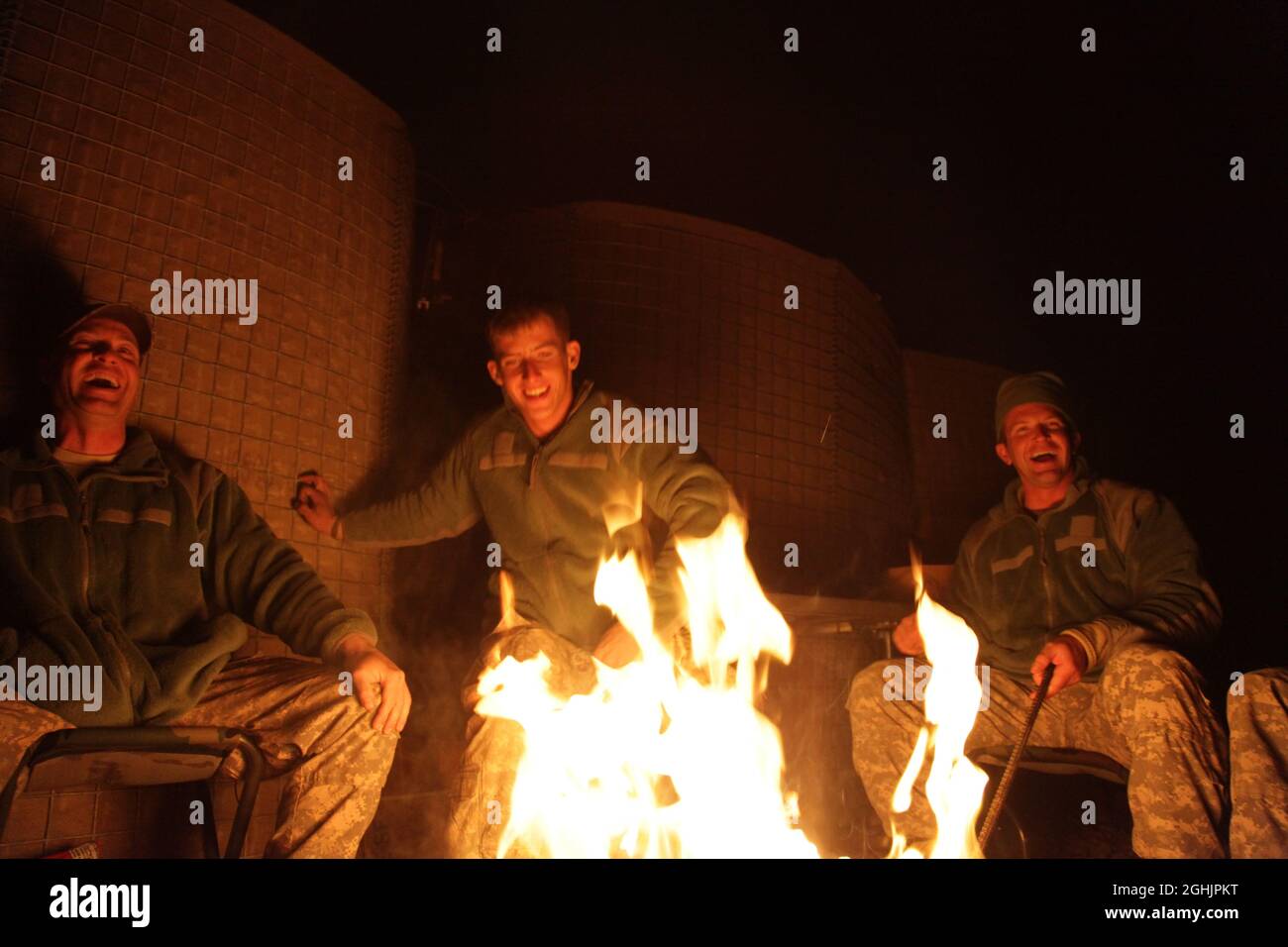 U.S. Army Soldiers sit around the fire pit to keep warm and share a ...