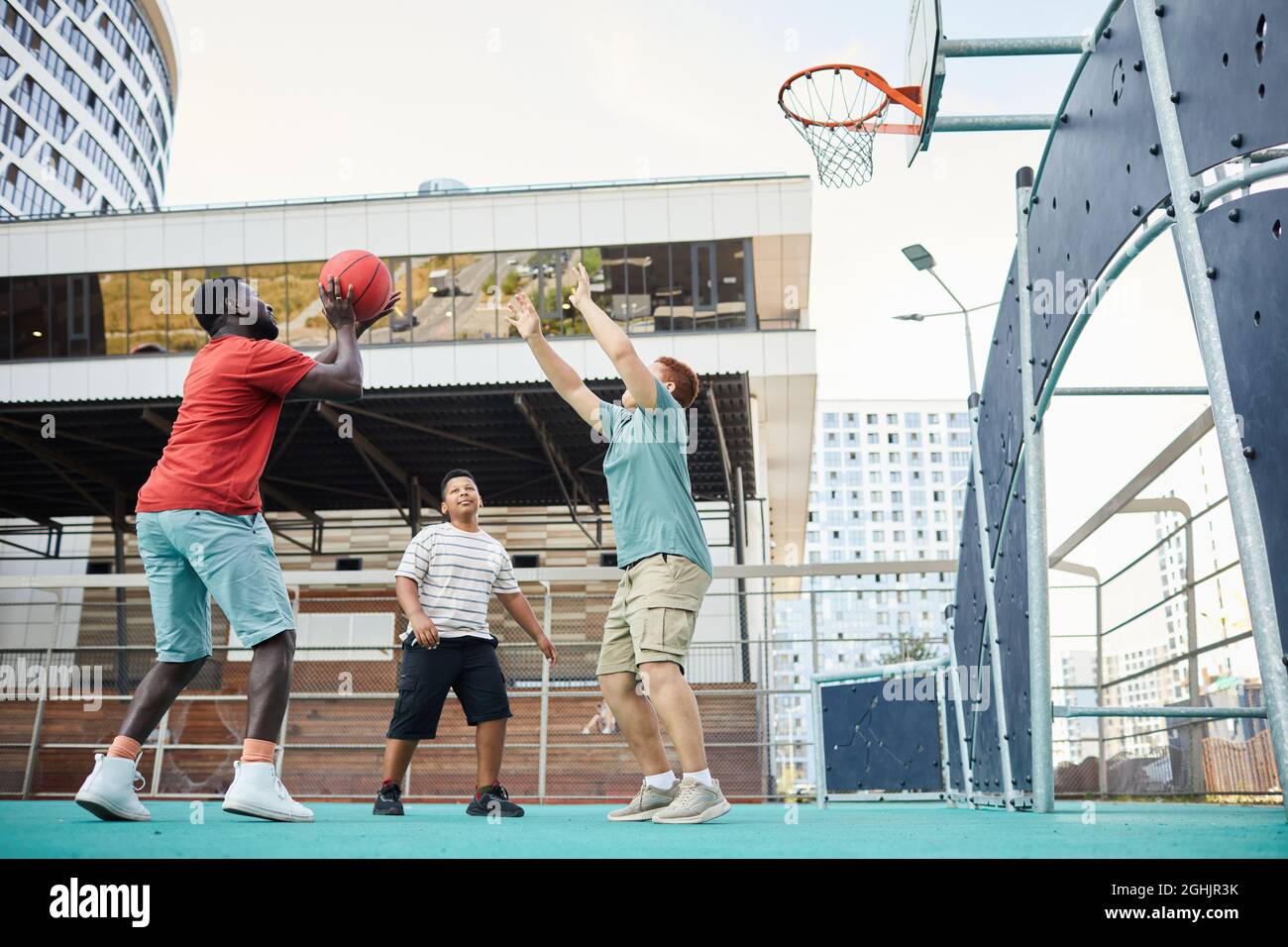 Boy Raising hands while making cuts under hoop while playing basketball ...