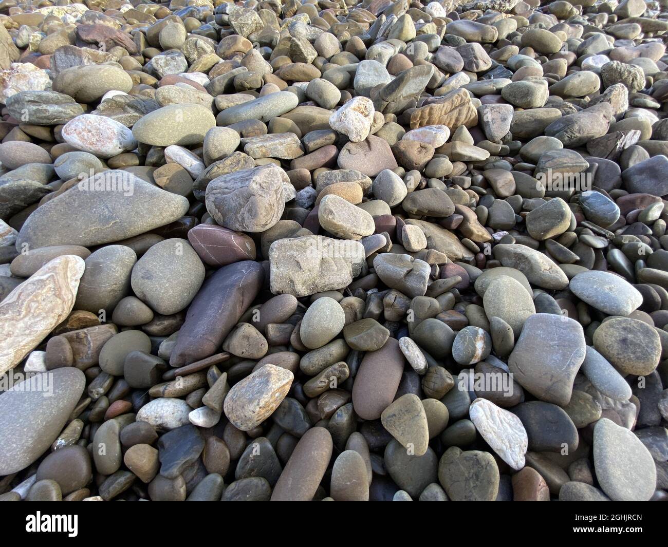 Natural background at the beach of colorful sea pebbles Stock Photo - Alamy