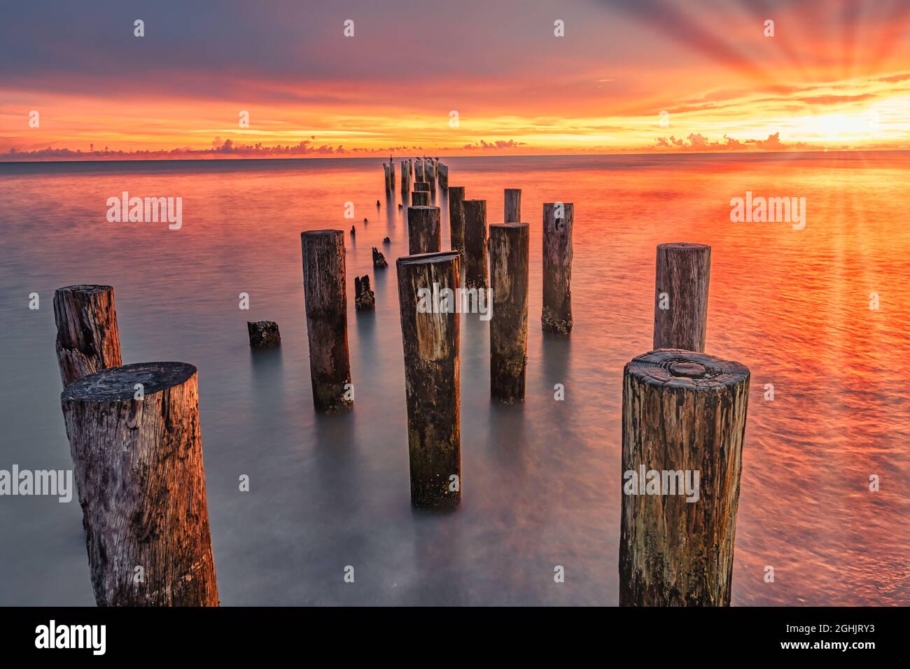 Scenic sunset with the beautiful beach and an old pier in Florida ...