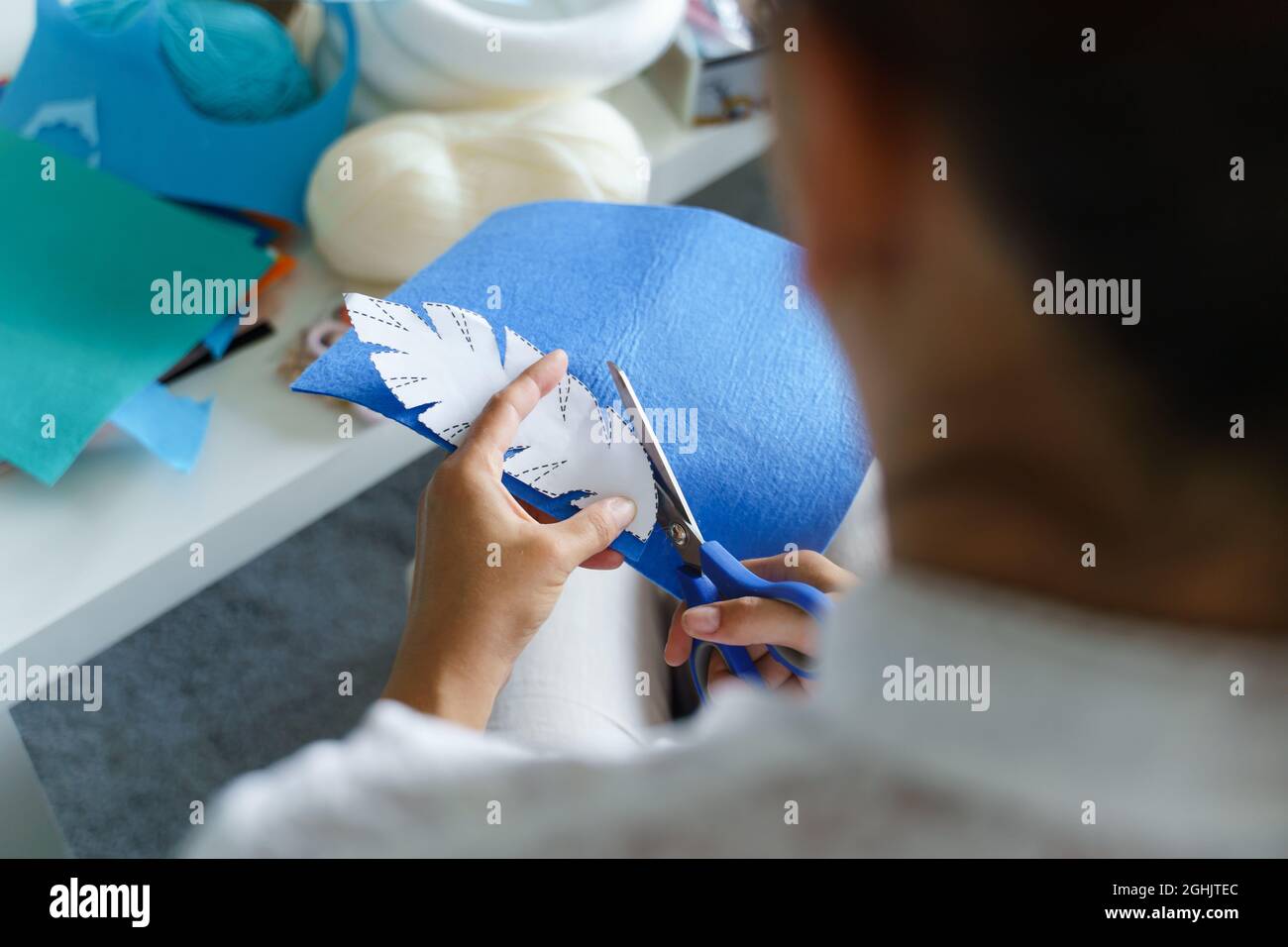 Close up on hands of unknown caucasian woman using scissors at home ...