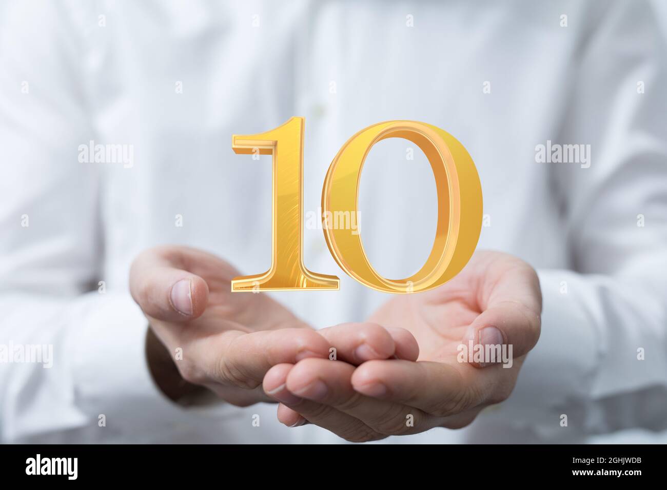3D rendered golden number 10 hovering over a man's hands Stock Photo ...