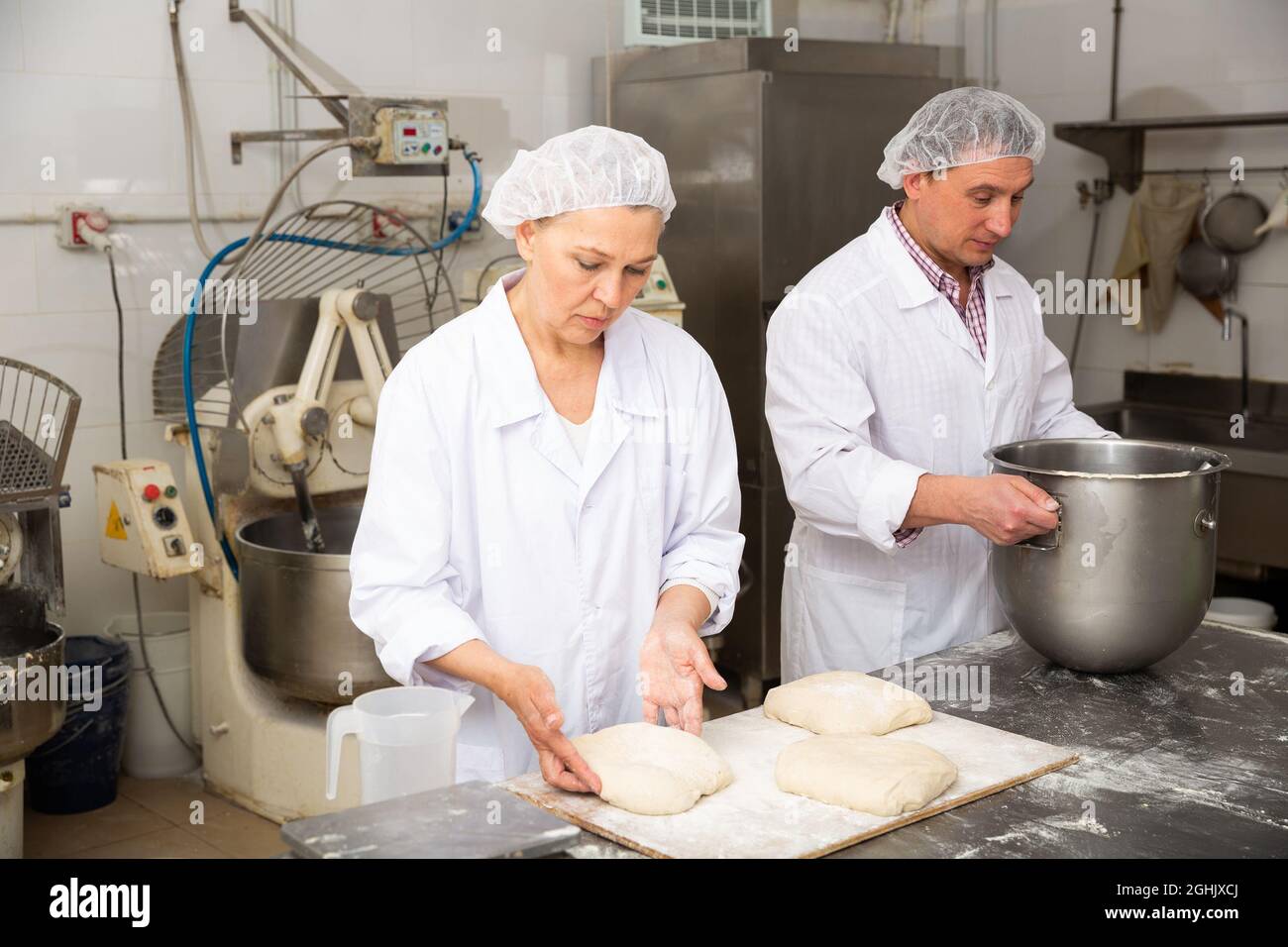 Female baker forming bread loaves from dough Stock Photo - Alamy
