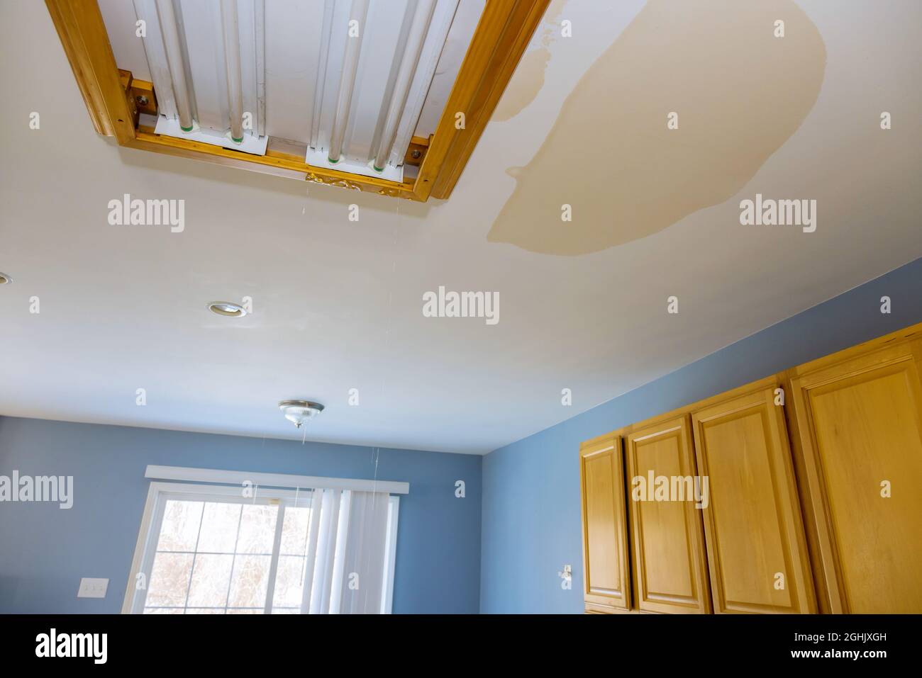 Water running from ceiling light fixture due to burst water pipe Stock ...