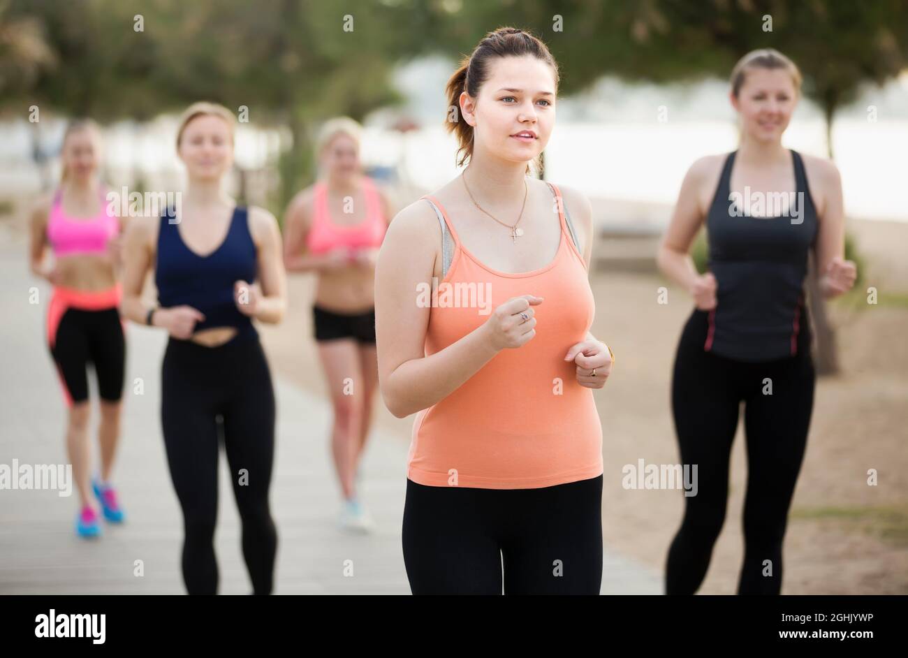 Positive girls running during outdoor workout Stock Photo - Alamy
