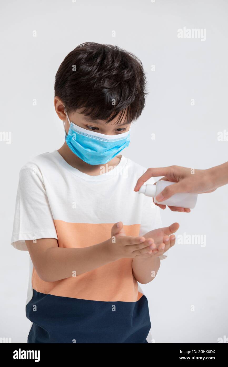 Little boy using hand sanitizer Stock Photo - Alamy