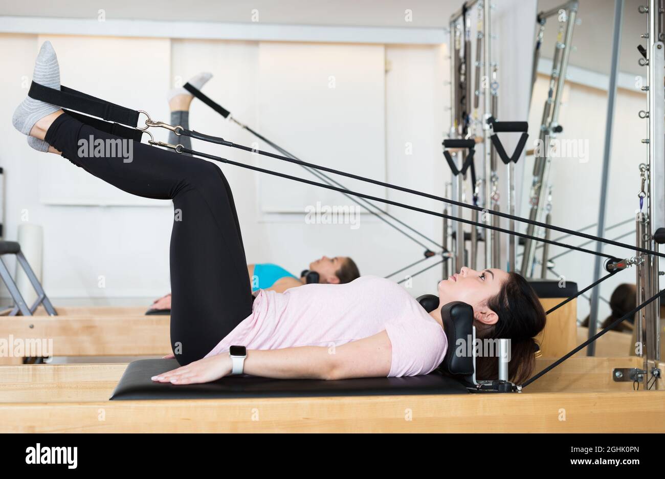 Woman exercising torson rotation at gym using pilates beds Stock Photo ...