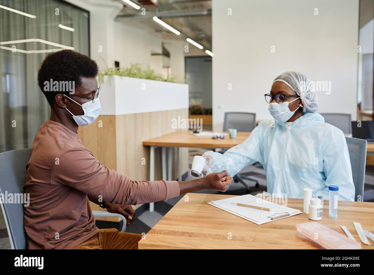 Medical nurse in PPE using infrared non-contact thermometer to check ...