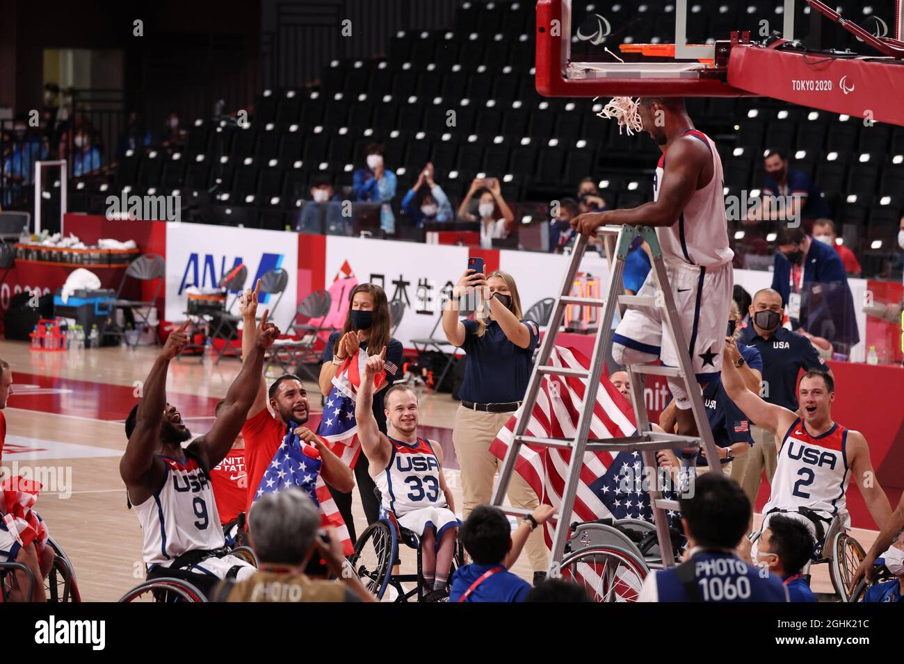 Brian Bell (USA) of Team USA shows the basketball hoop net that he cut ...