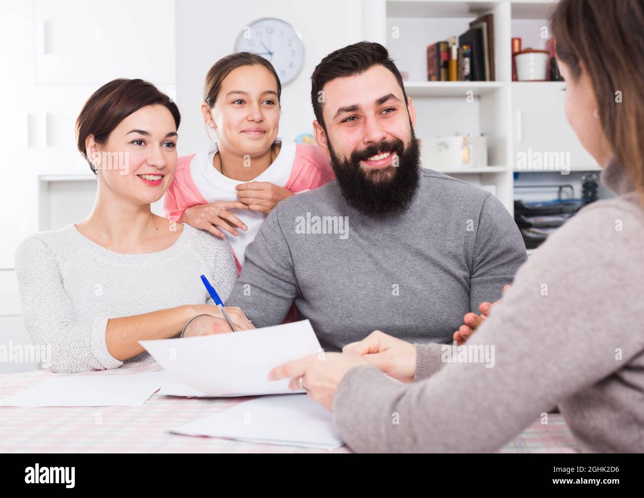 Parents signing property papers Stock Photo - Alamy
